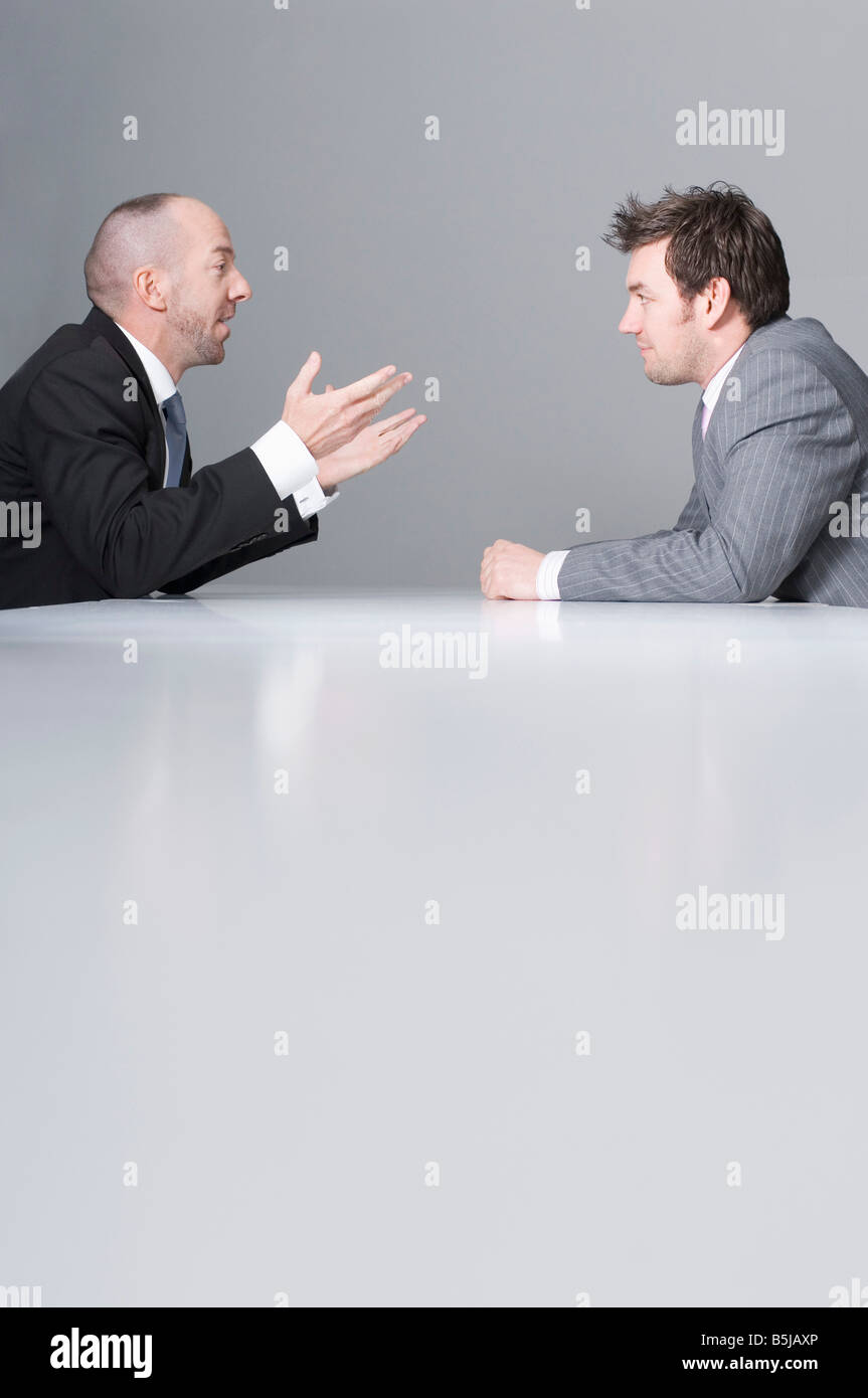 two businessmen sitting at conference table Stock Photo - Alamy
