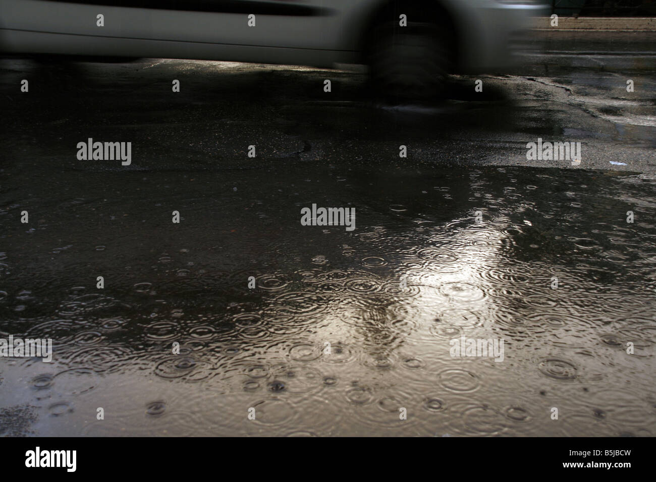 lots rain drops falling in water puddle in street Stock Photo - Alamy