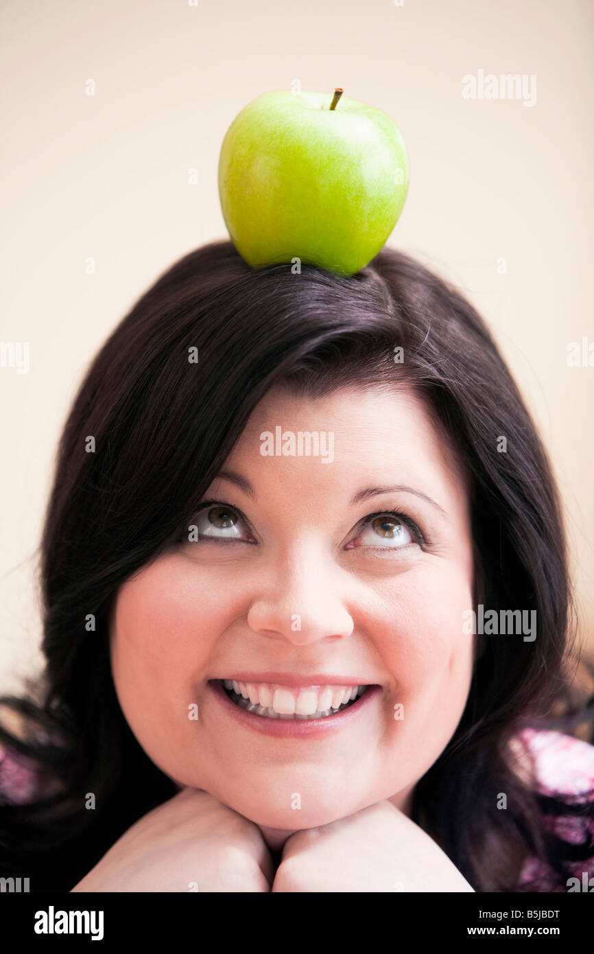 portrait of overweight woman balancing apple on her head Stock Photo ...