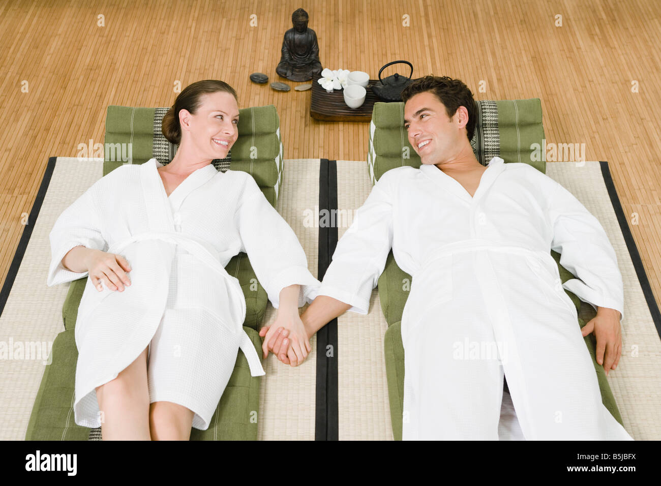 couple relaxing in spa holding hands Stock Photo - Alamy