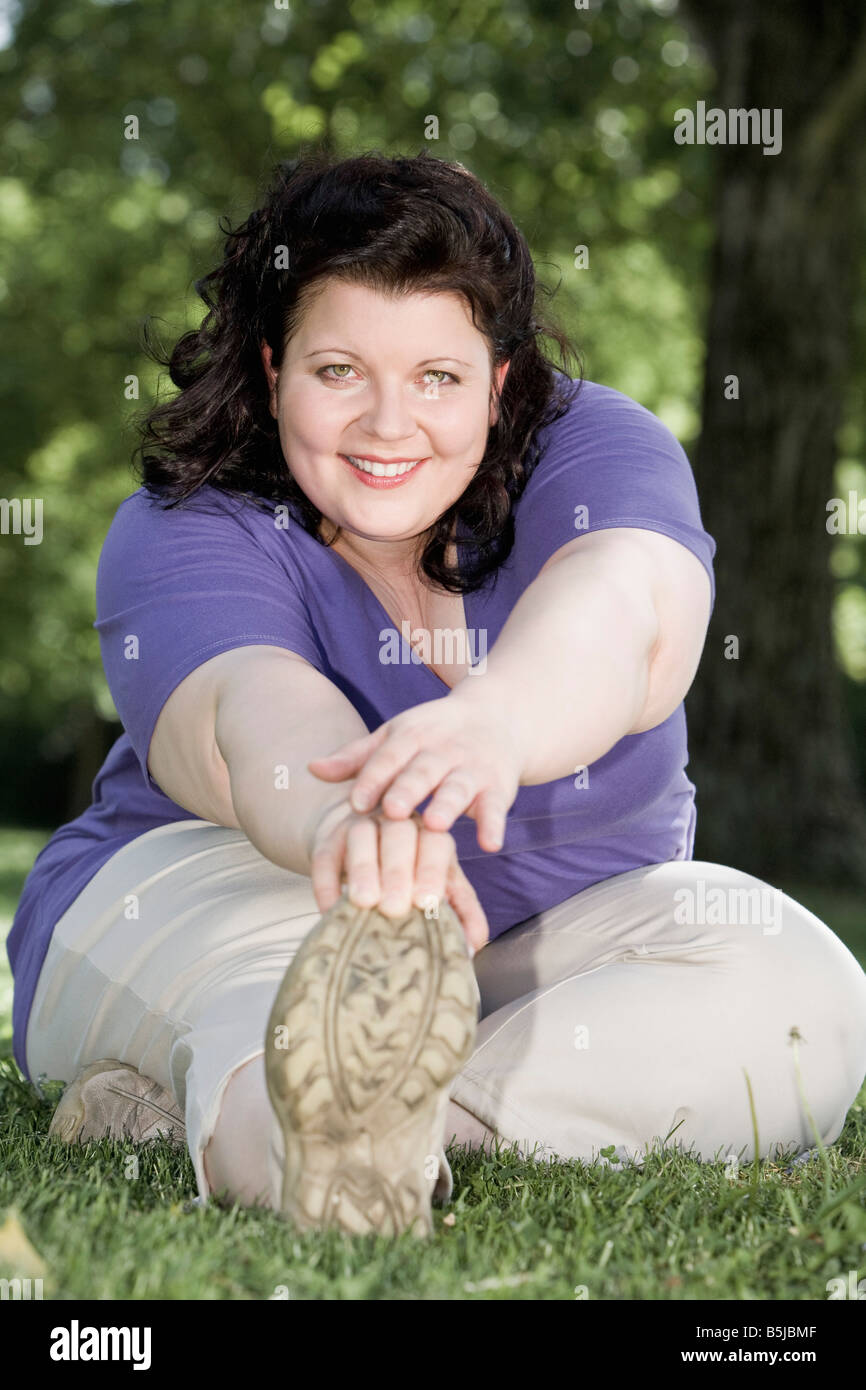 overweight woman doing stretching exercises in park Stock Photo - Alamy