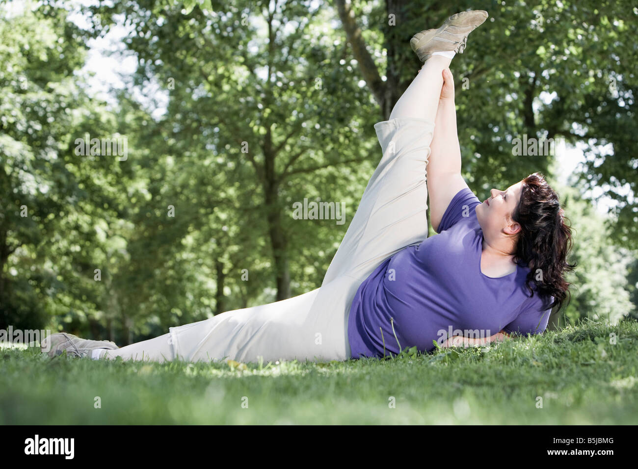 overweight woman doing stretching exercises in park Stock Photo - Alamy