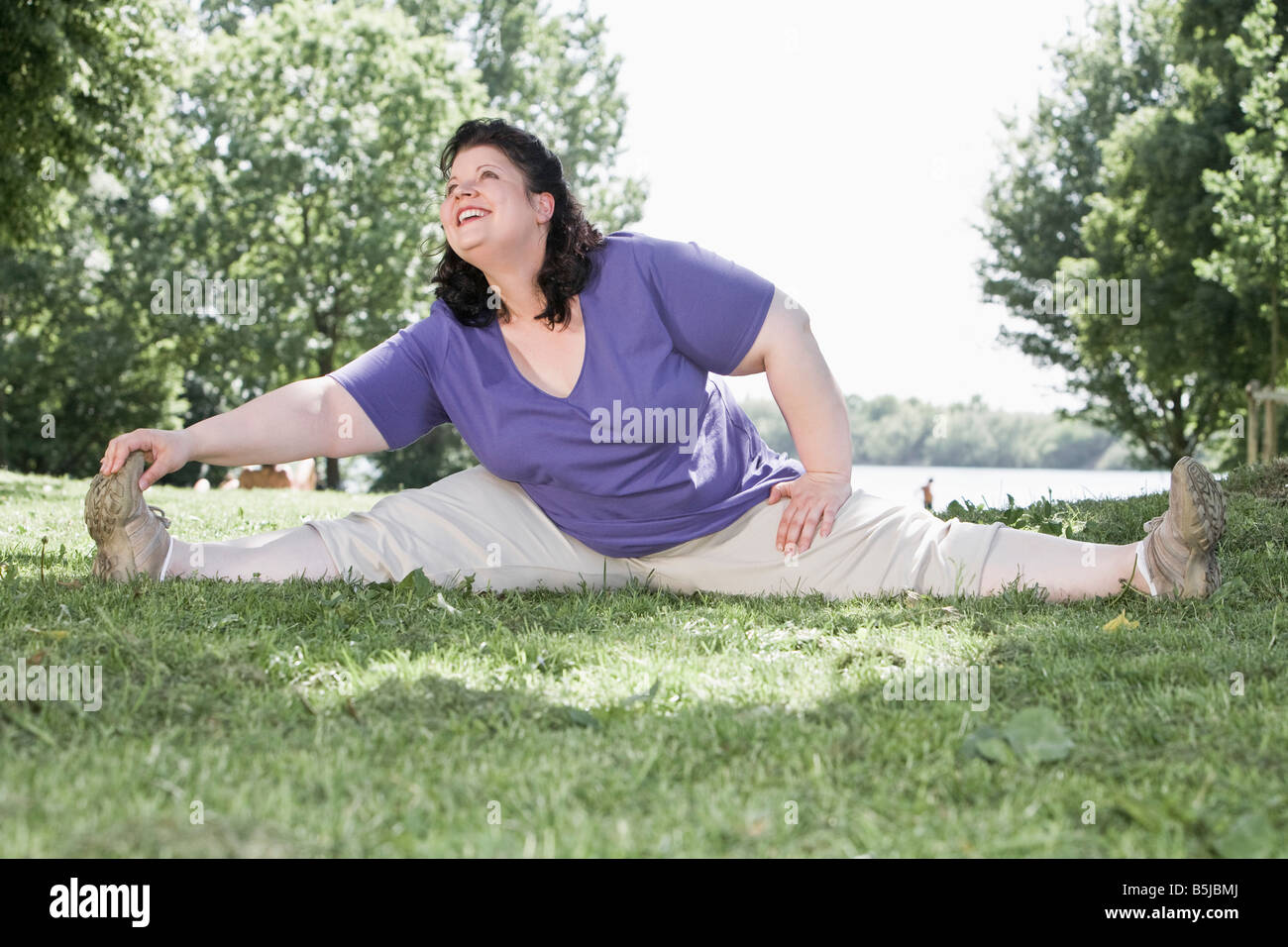 overweight woman doing stretching exercises in park Stock Photo - Alamy