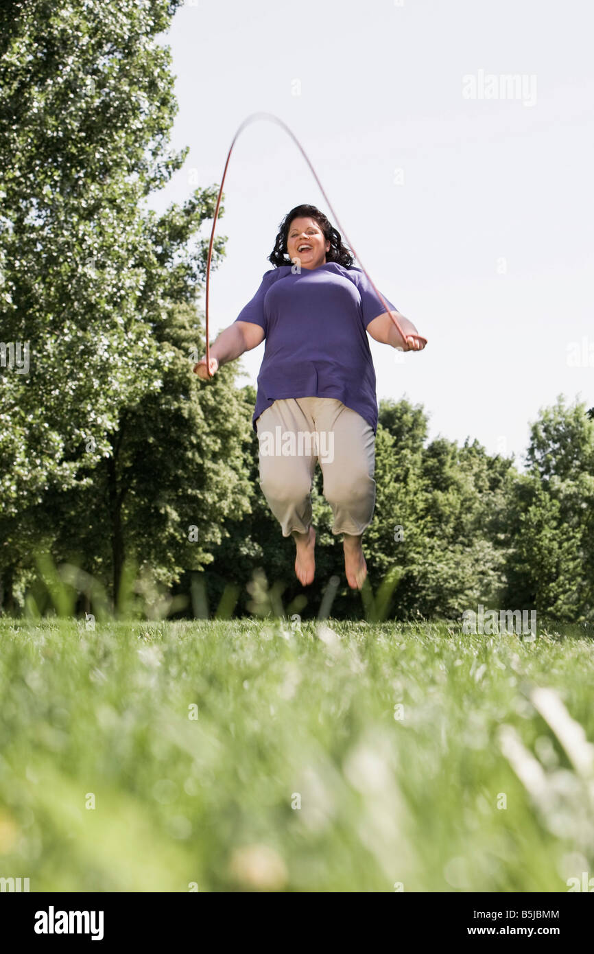 overweight woman skipping in park Stock Photo - Alamy