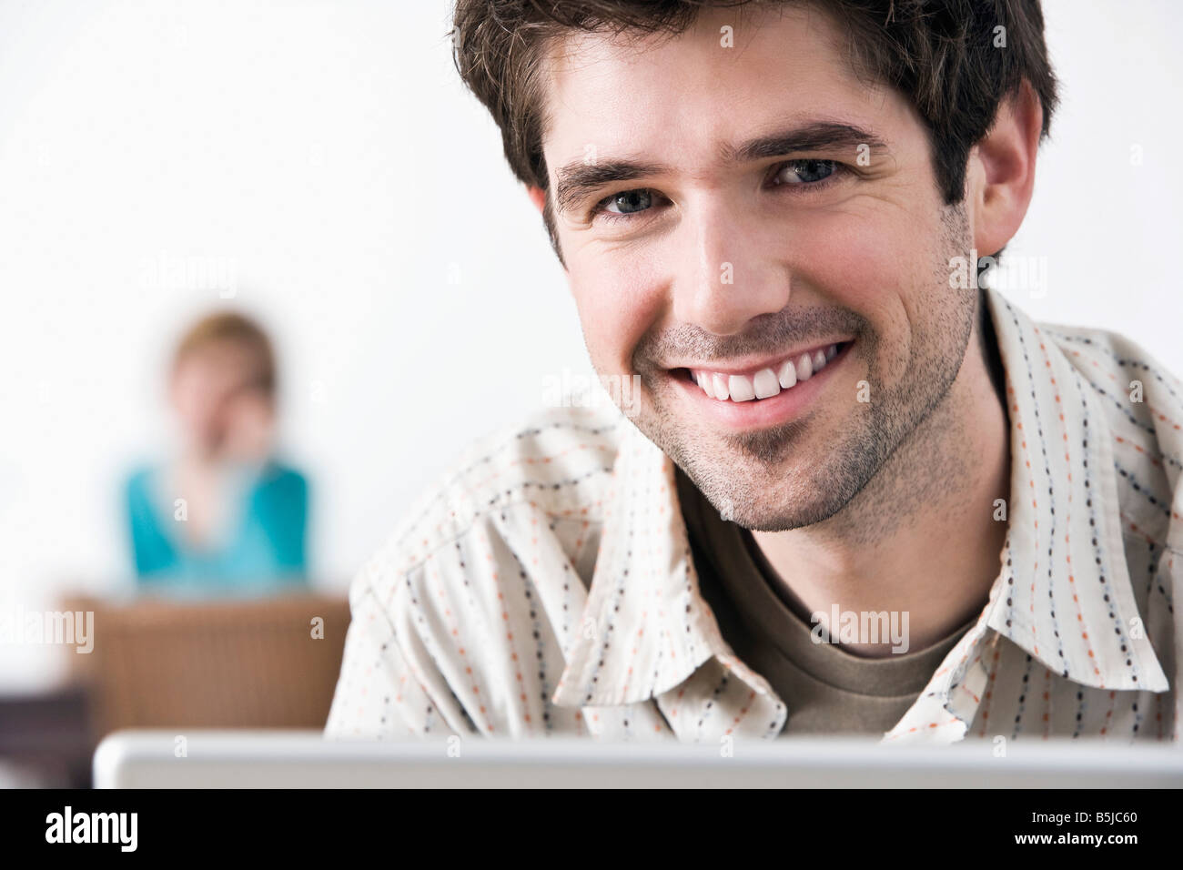 headshot of young man at home working on laptop computer Stock Photo ...