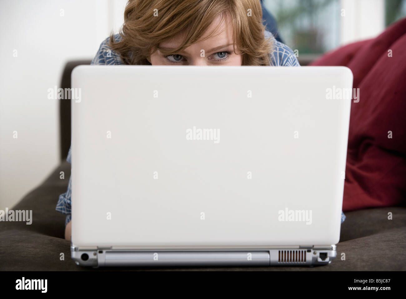portrait of young woman hiding behind laptop computer Stock Photo - Alamy