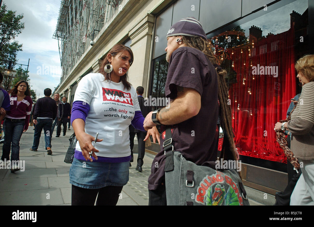 A Chugger talking to shoppers in Oxford Street London UK Stock Photo ...