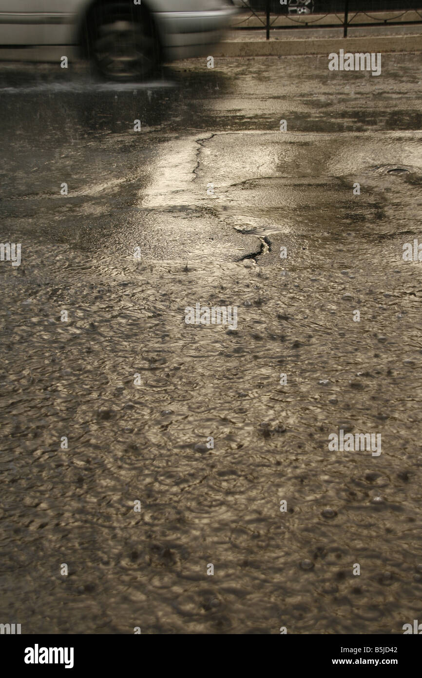 lots rain drops falling in water puddle in street Stock Photo - Alamy