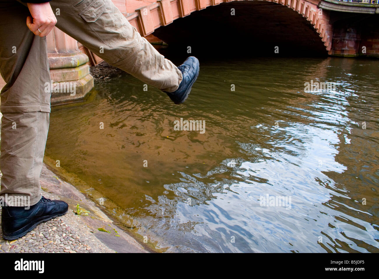 Man stepping over water Strasbourg June 2006 Stock Photo - Alamy