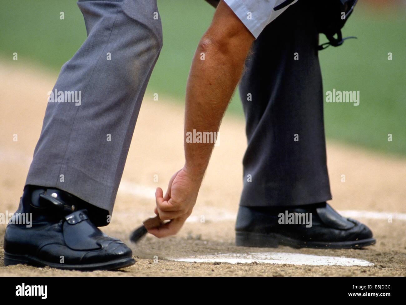 Umpire dusting off home plate Stock Photo - Alamy