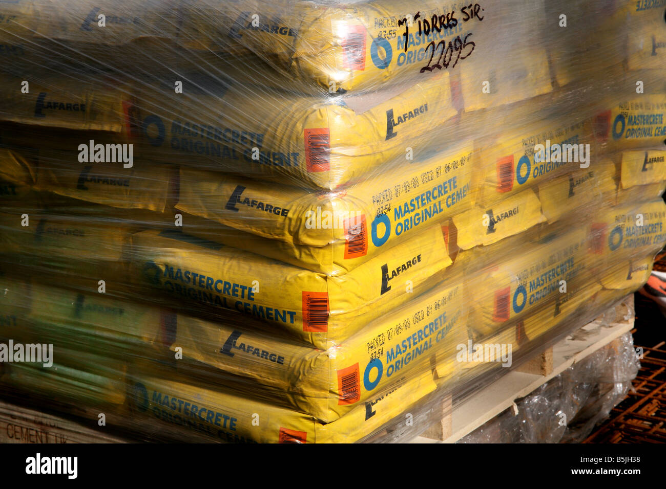 Shrink wrapped bags of cement on building site Stock Photo - Alamy