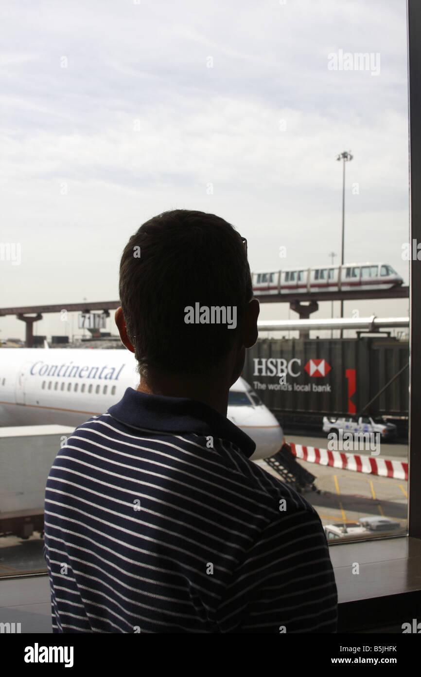 Man looking out of a window of Houston International Airport, Texas ...