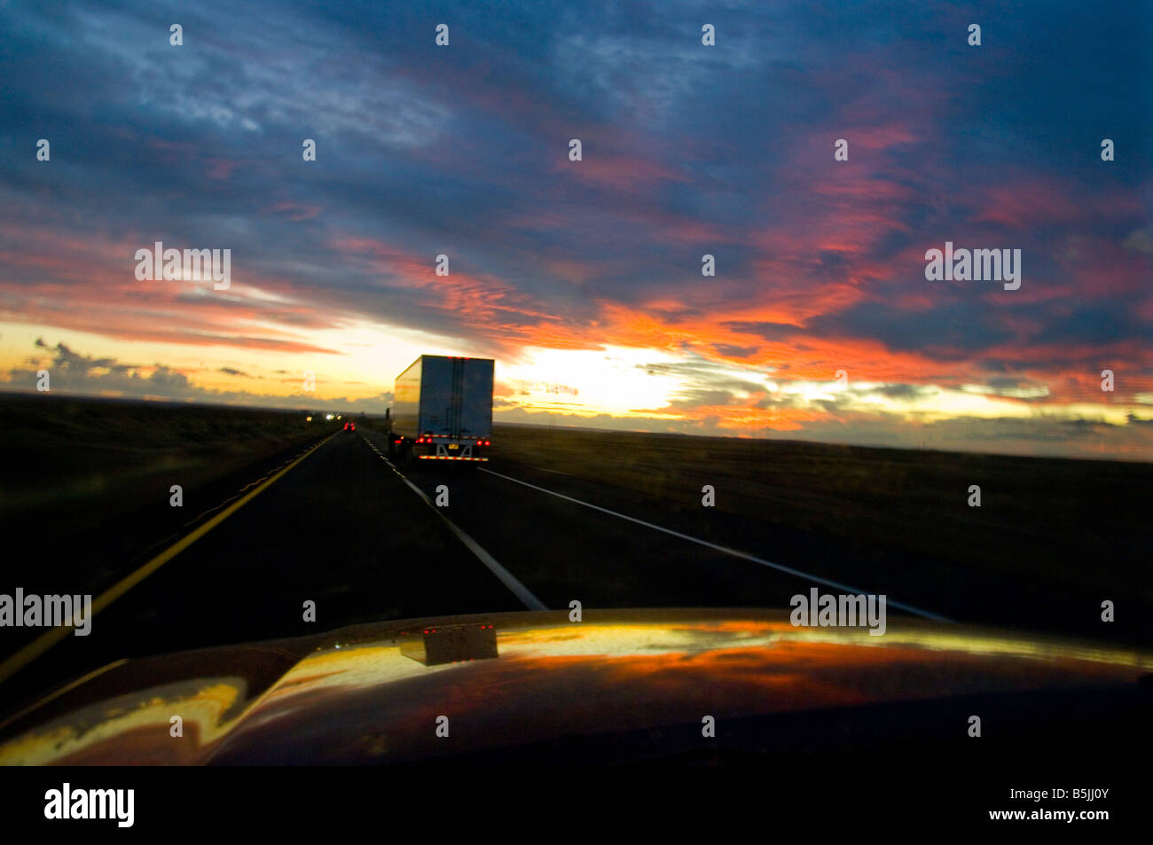 A semi drives westbound into the sunset on Interstate 40, Arizona Stock ...