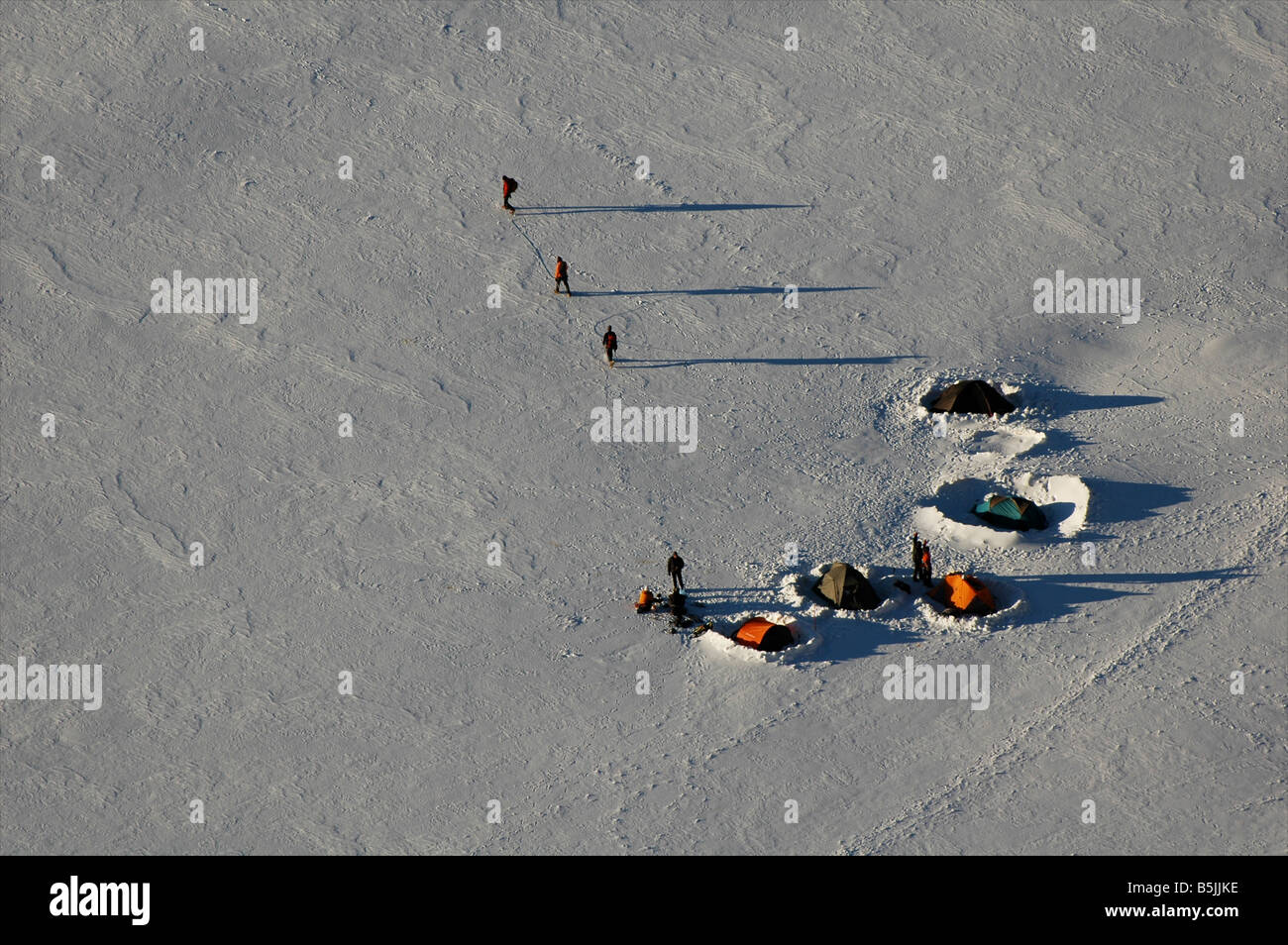 Mountain climbers leave their base camp in the alps Stock Photo - Alamy