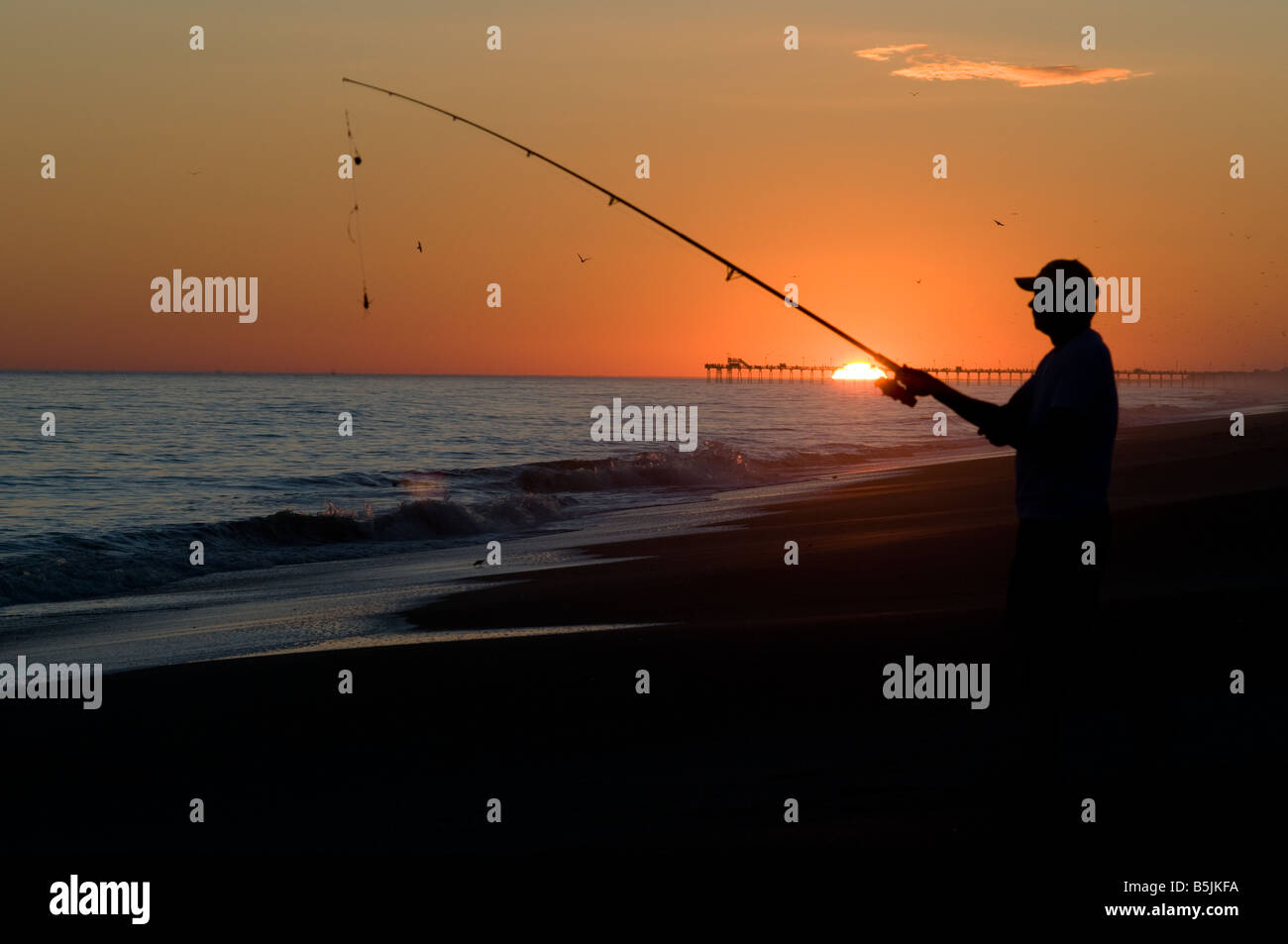 Fishing at sunset Stock Photo - Alamy