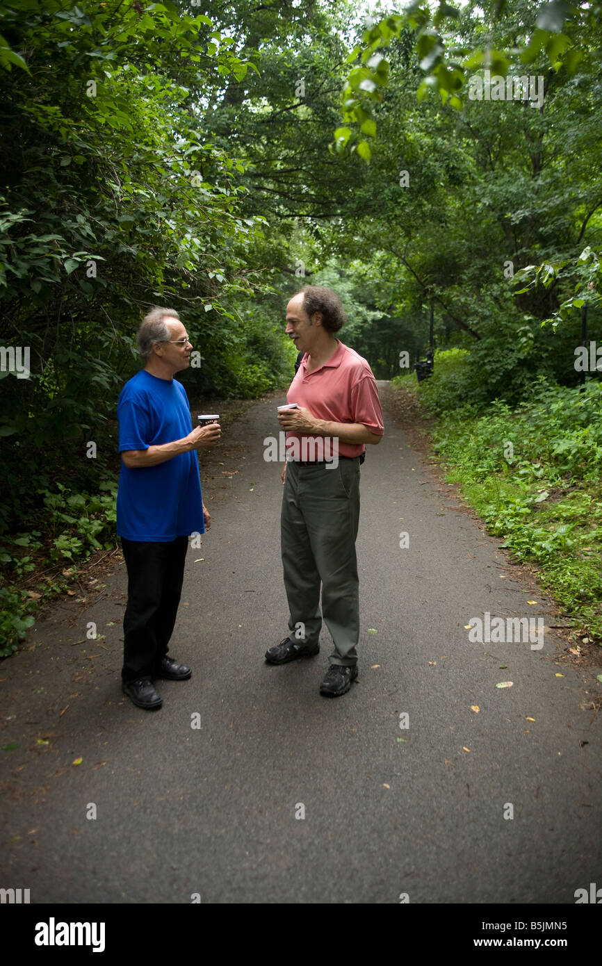 Two sixty something year old men spend some time together in a park in ...