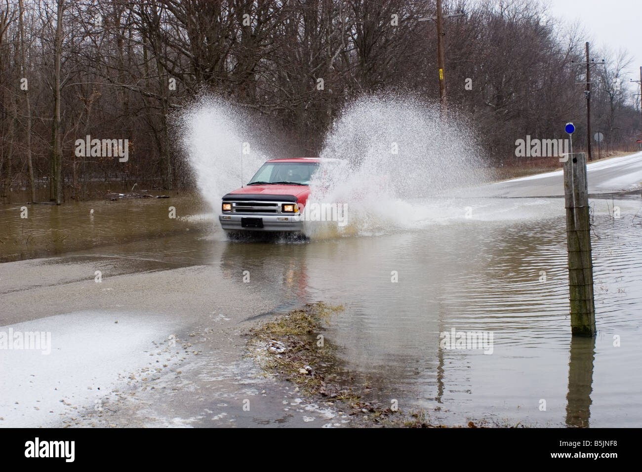 Car driving quickly through water on a flooded road Stock Photo - Alamy