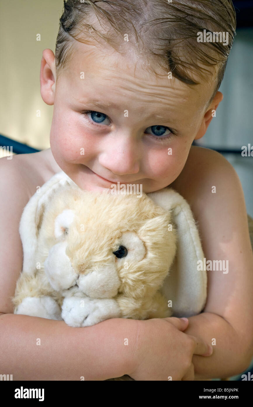 Young boy cuddling a toy rabbit Stock Photo - Alamy