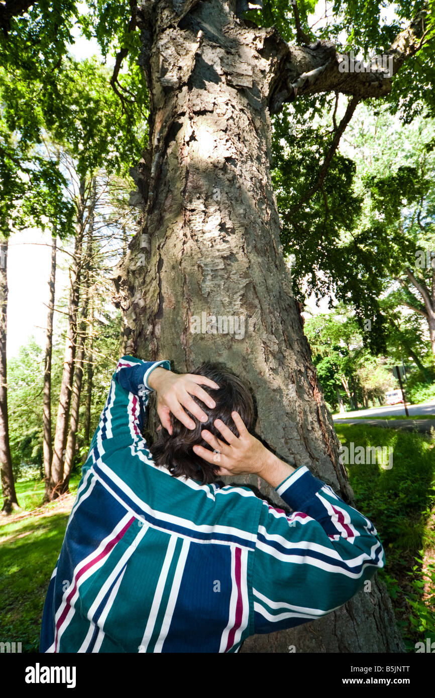 Man standing next to a tree at a park MODEL RELEASED Stock Photo - Alamy