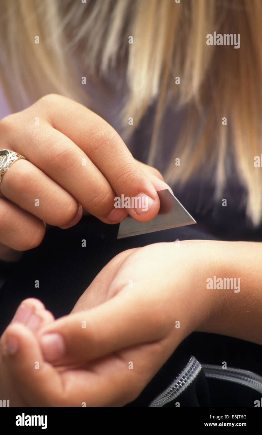 teenage girl cutting wrist with razor blade Stock Photo - Alamy