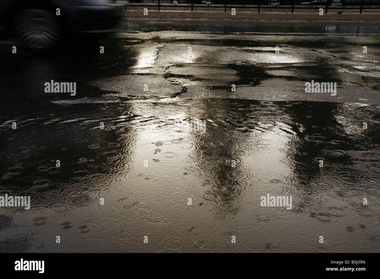 lots rain drops falling in water puddle in street Stock Photo - Alamy