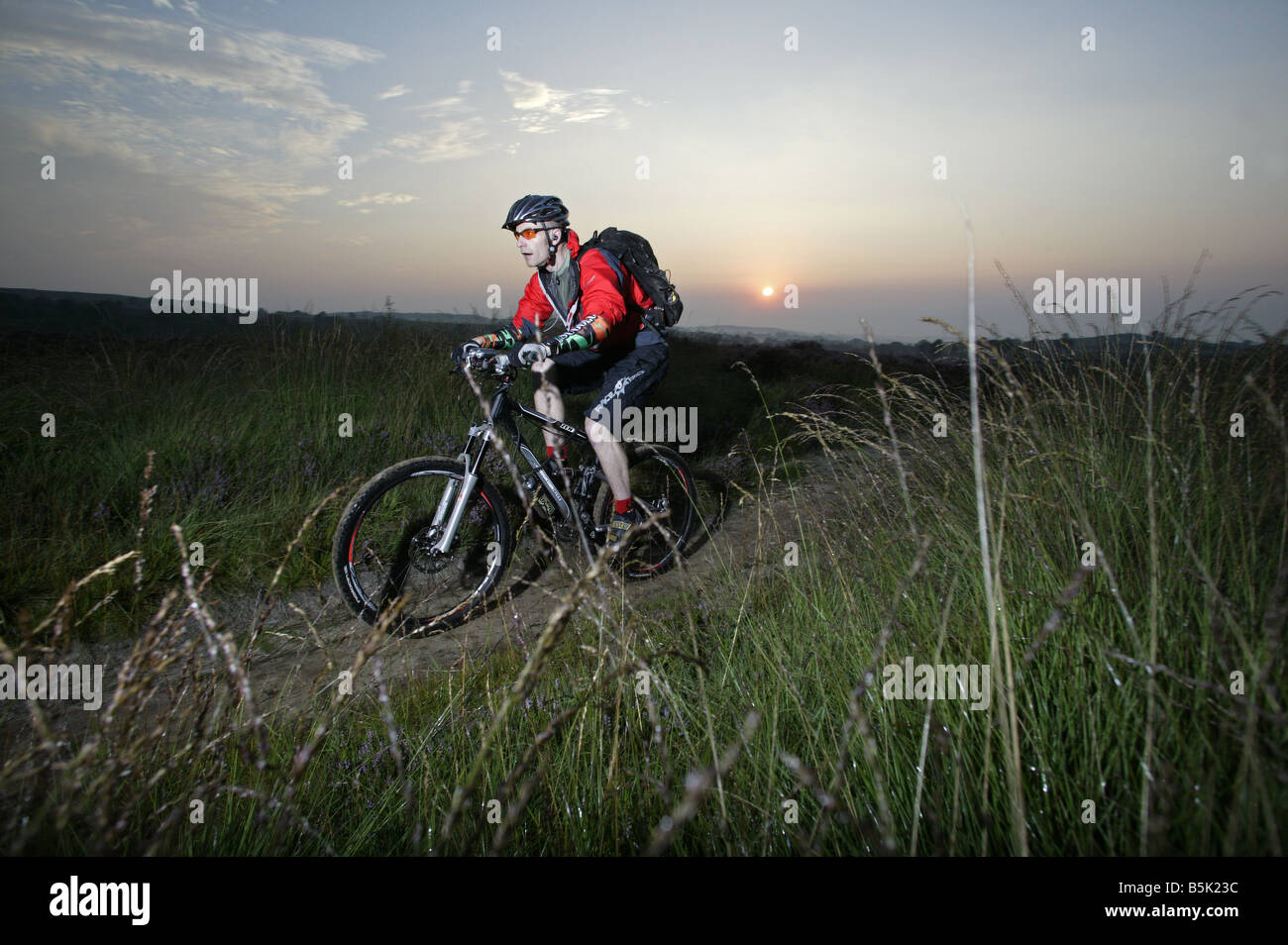 A man riding a mountain bike at sunrise Stock Photo - Alamy