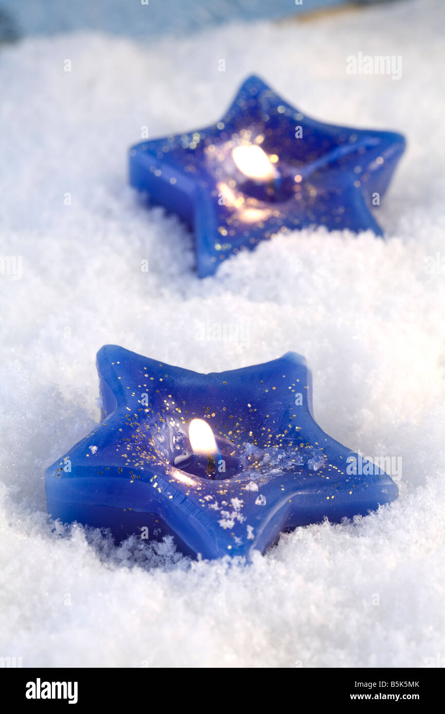 Two blue candles in snow Stock Photo - Alamy