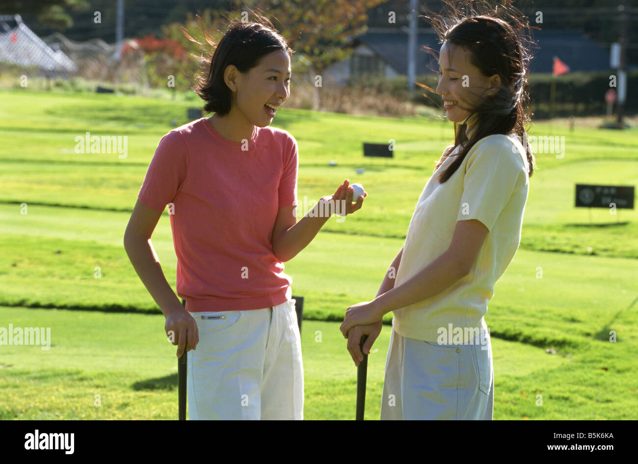Two young Asian women playing mini golf Stock Photo - Alamy