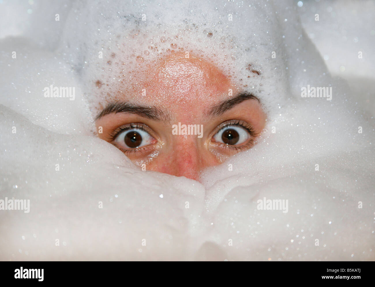 Woman with wide open eyes in foamy bath tub Stock Photo - Alamy