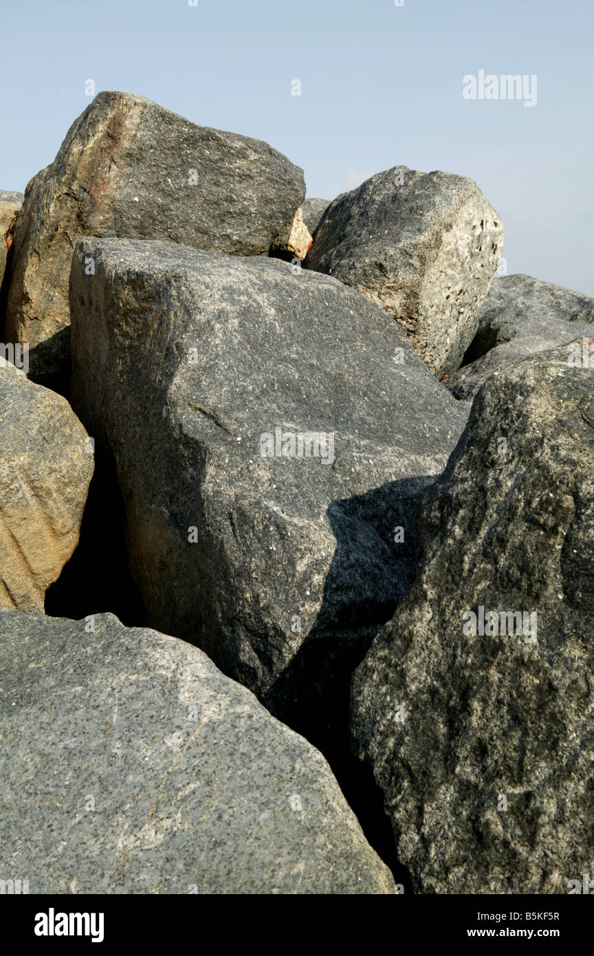 cropped detail of sea defense rocks in summer with blue sky and space ...