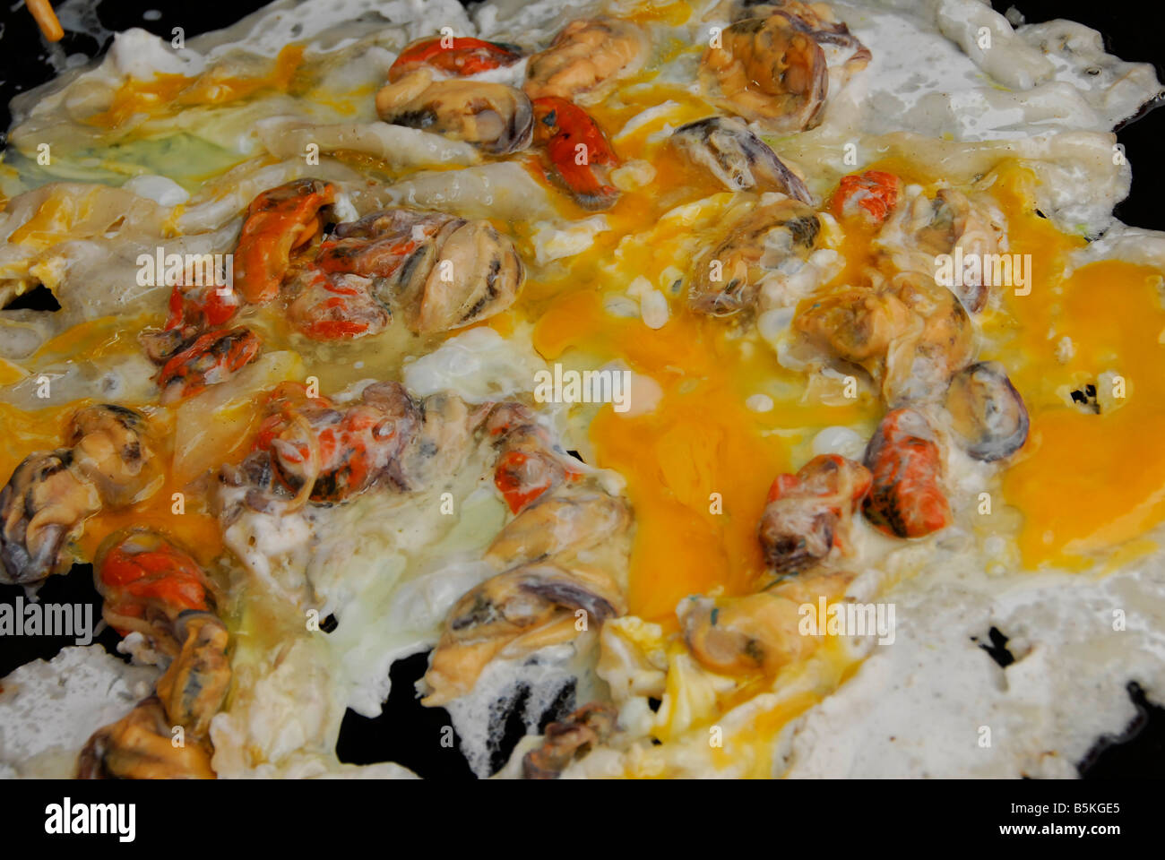 Thai food,Stir fried mussel with egg and flour in frying pan Stock Photo - Alamy