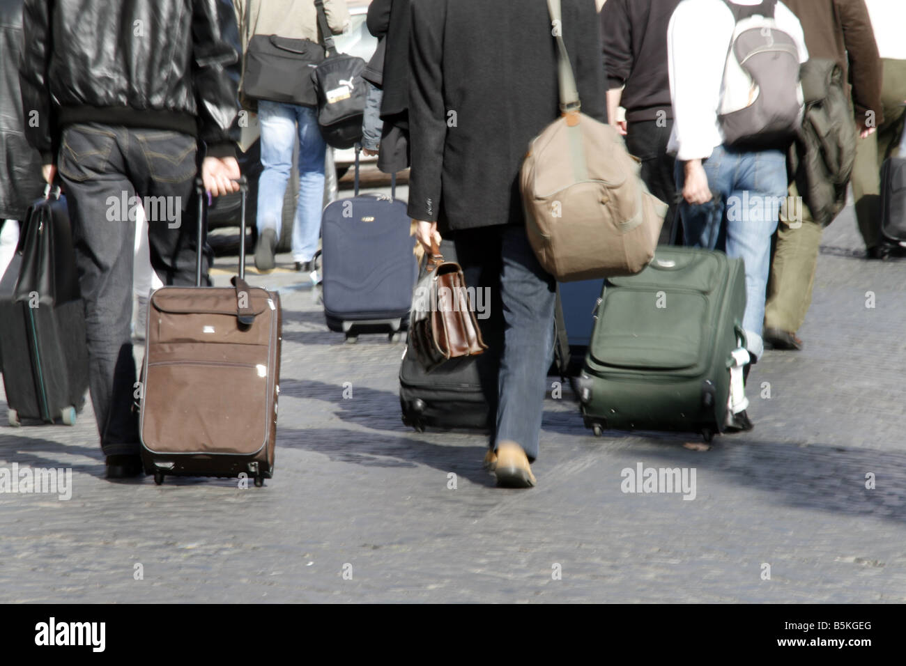 many people pulling trolley luggage cases in town Stock Photo - Alamy
