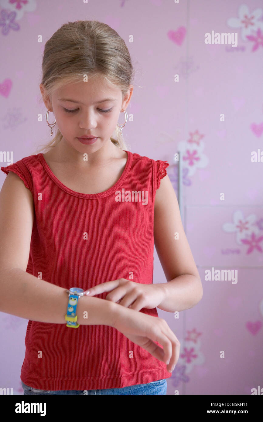 Blond girl is looking at her watch Stock Photo - Alamy