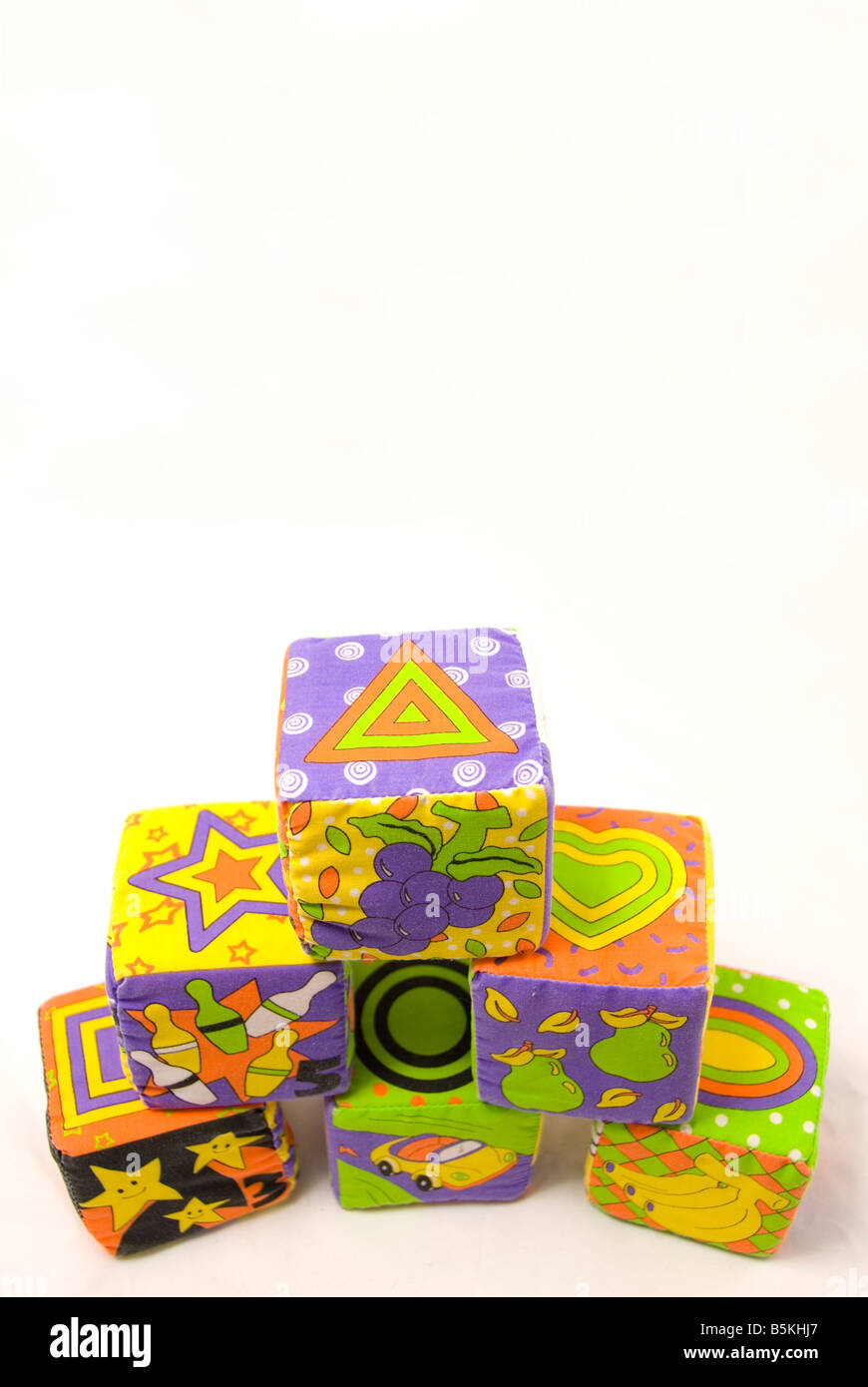 Six Colourful Material Baby Toy Blocks in a Triangular Stack on White ...