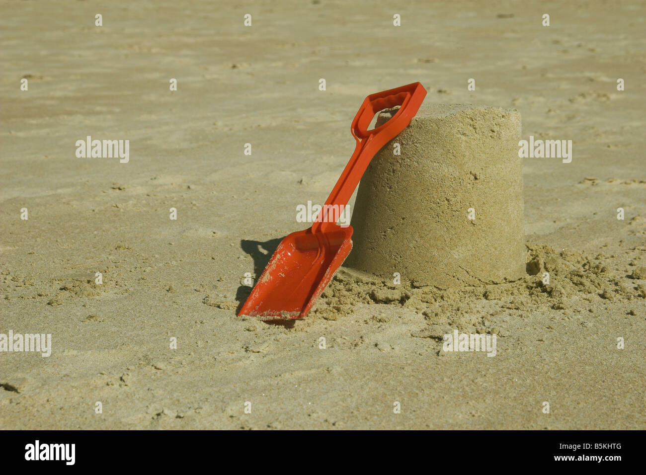 Red Spade and Sandcastle Stock Photo - Alamy