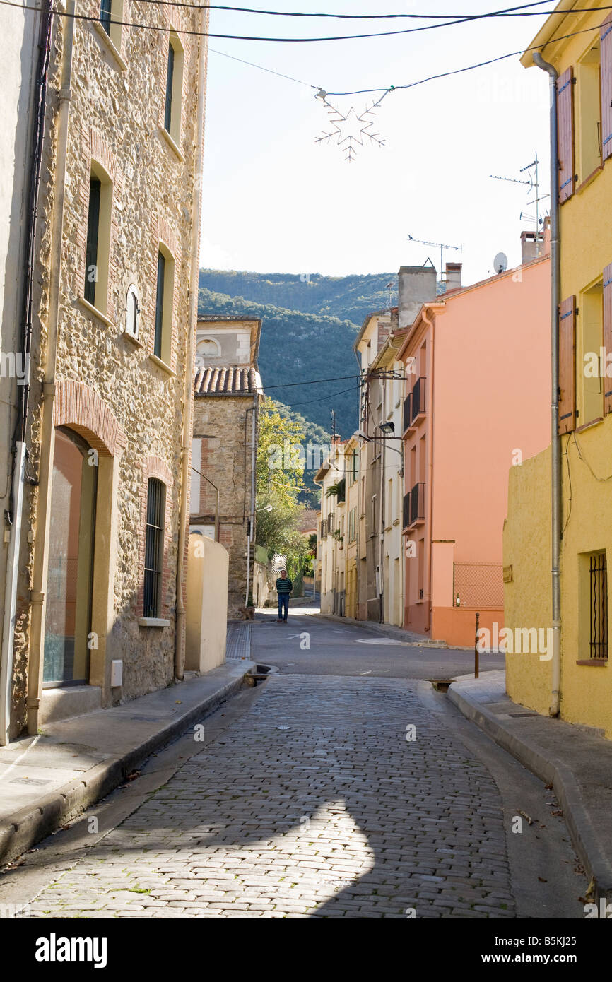 A view down a small street in France with mountains behind Stock Photo ...
