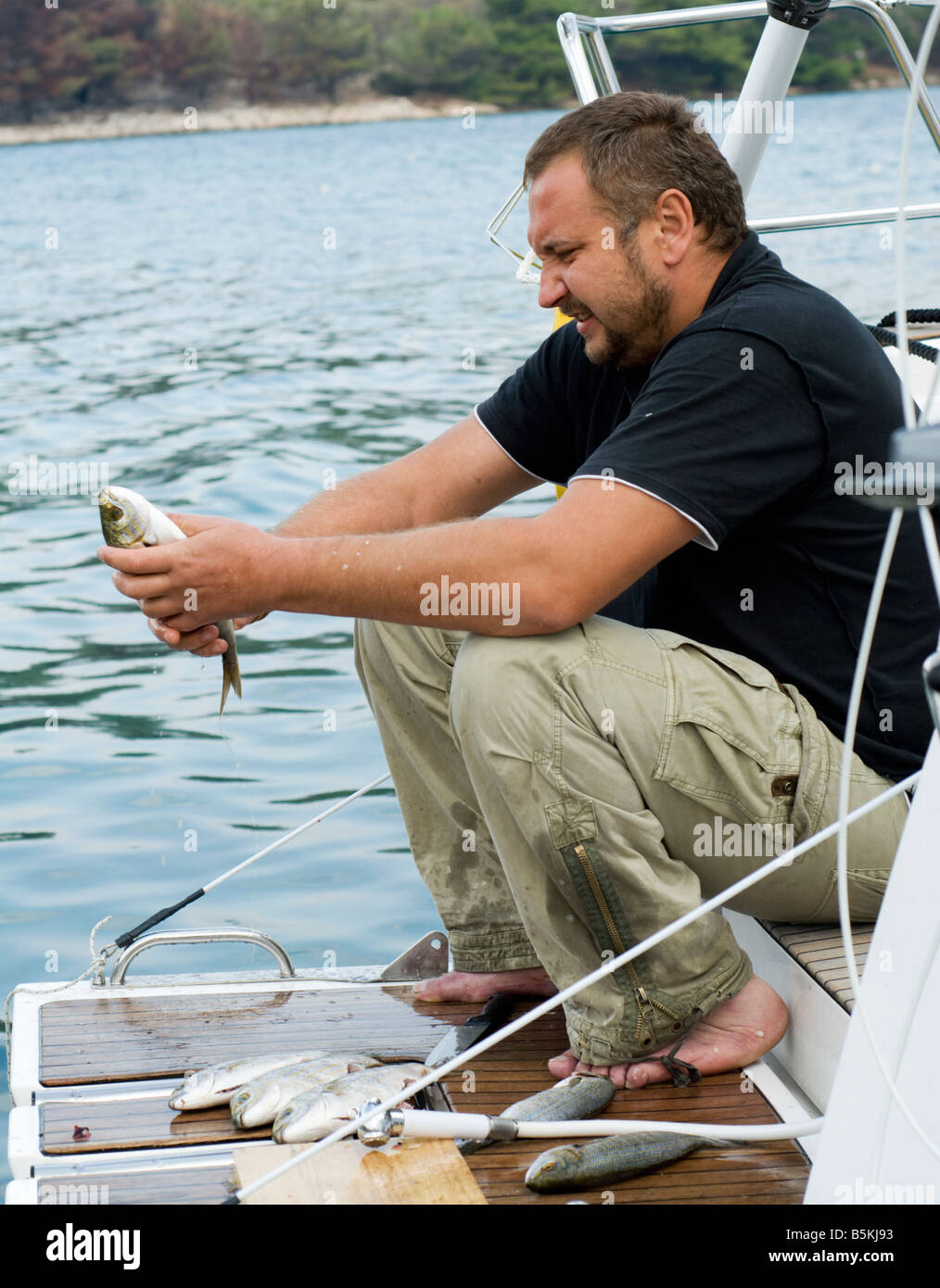 a guy gutting fish for dinner Stock Photo - Alamy