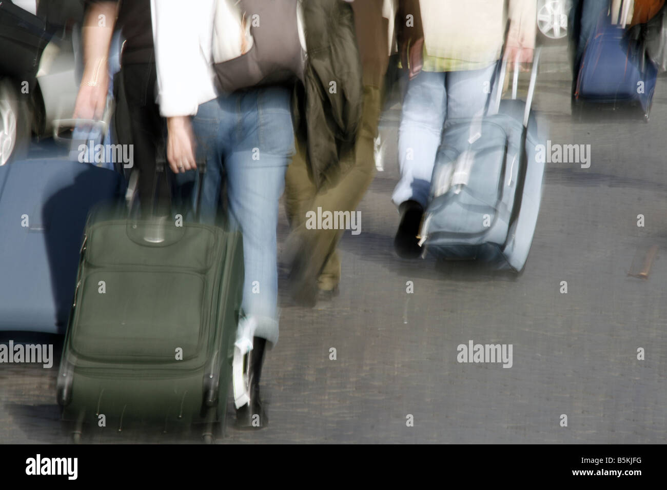 many people pulling trolley luggage cases in town Stock Photo - Alamy