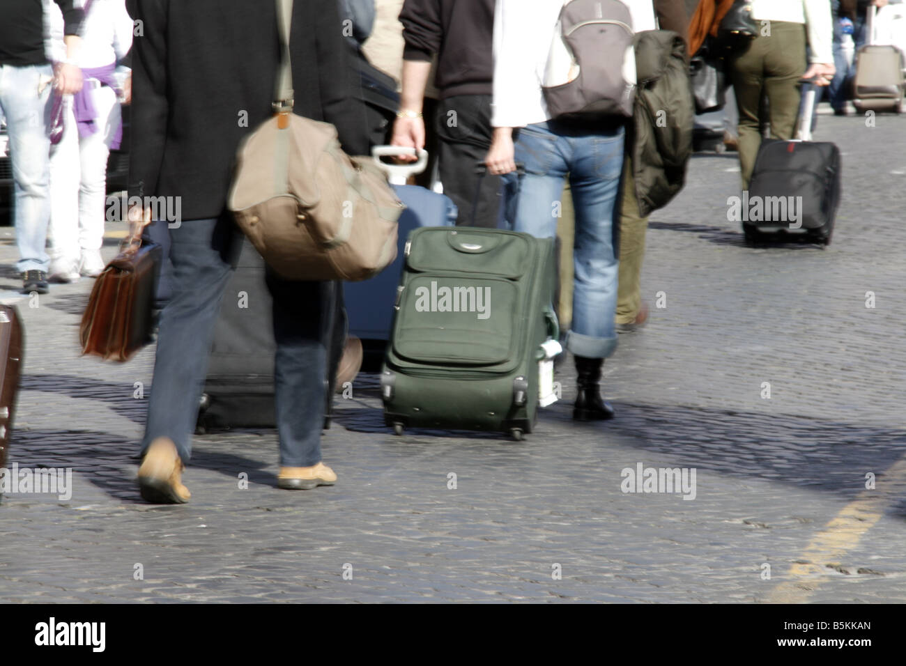 many people pulling trolley luggage cases in town Stock Photo - Alamy