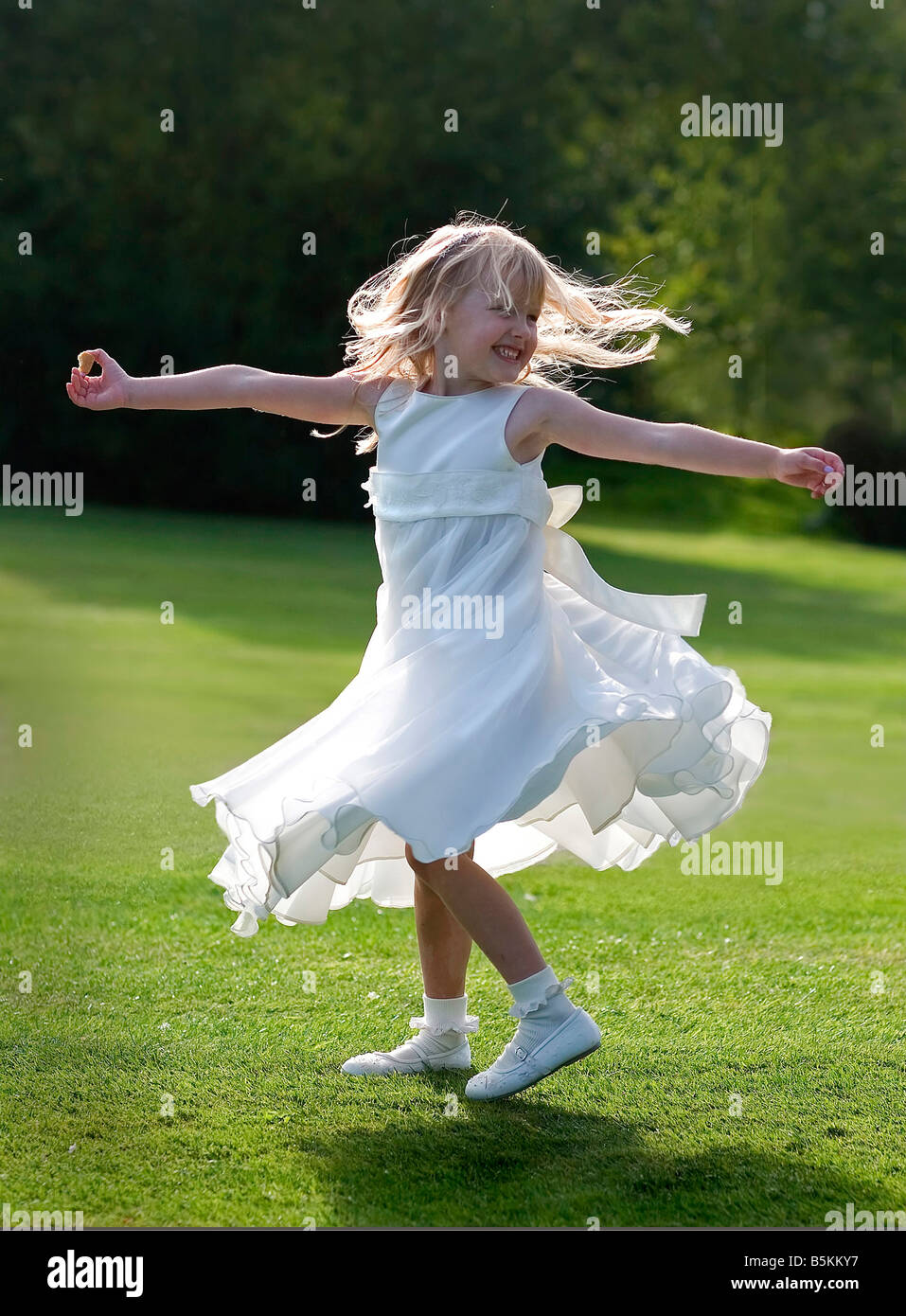 A young bridesmaid spinning round to make her dress fly out Stock Photo ...