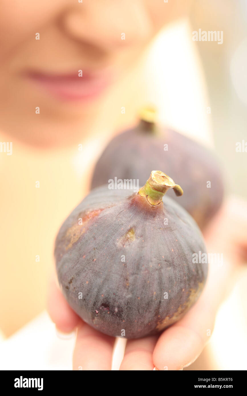 Young Woman Holding Two Figs Model Released Stock Photo - Alamy