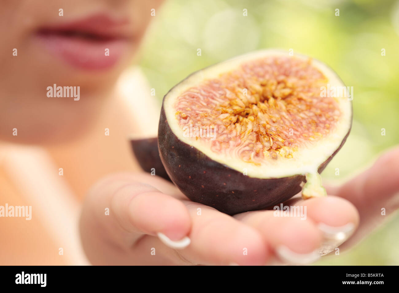 Young Woman Holding A Cut Fig Model Released Stock Photo - Alamy