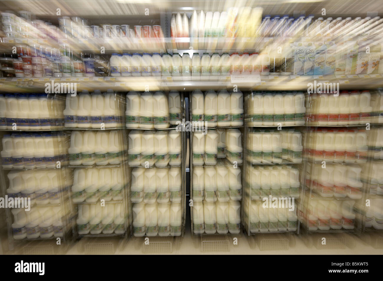 Milk stacked on supermarket shelf fast blurred effect Stock Photo - Alamy