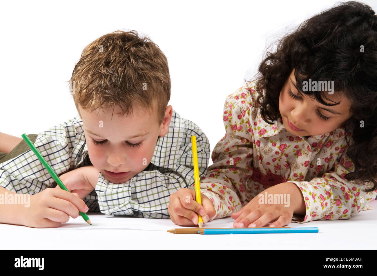 Two friends are drawing together lying on the floor Stock Photo - Alamy