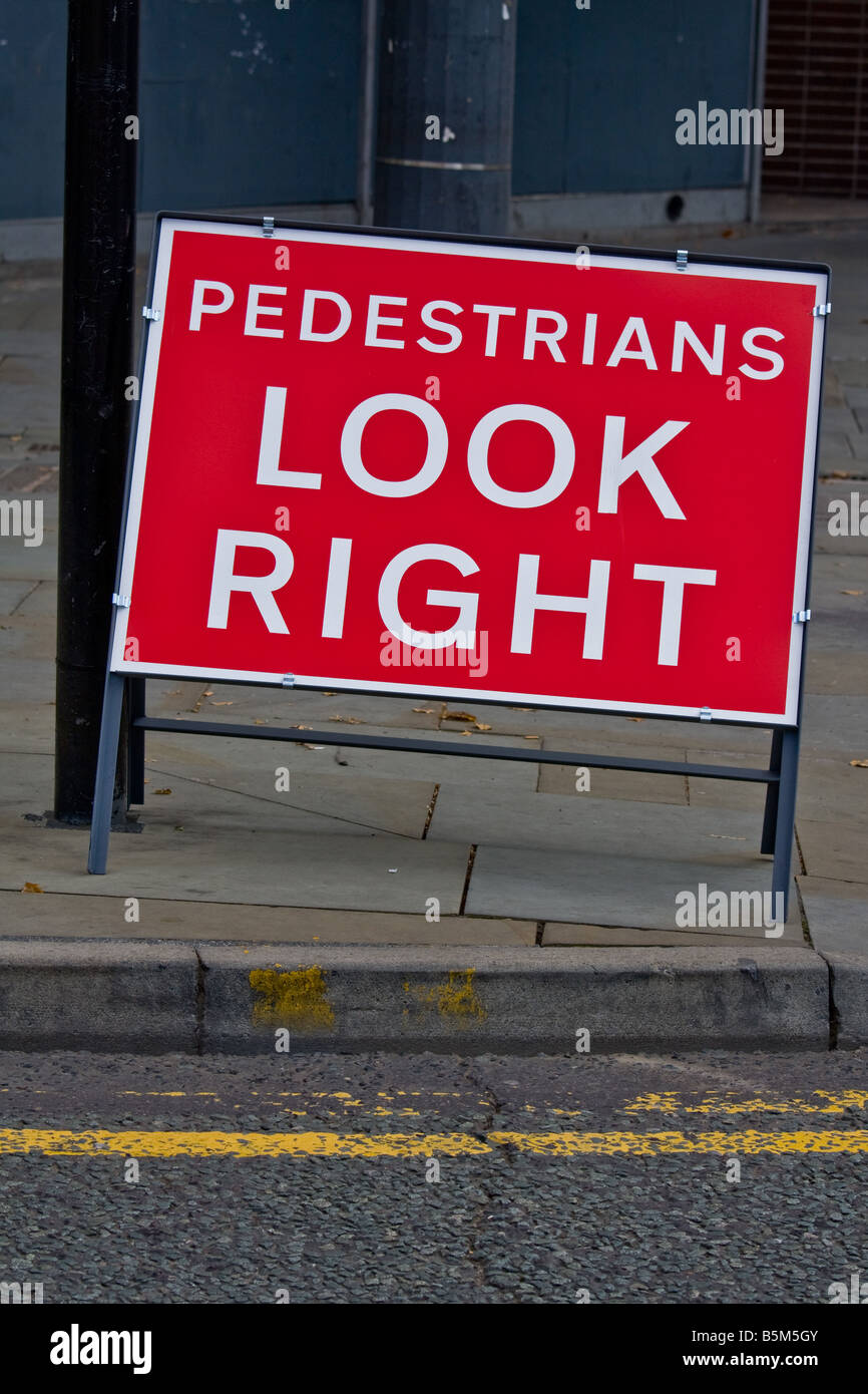 A 'Pedestrians Look Right' road sign on a slope Stock Photo - Alamy