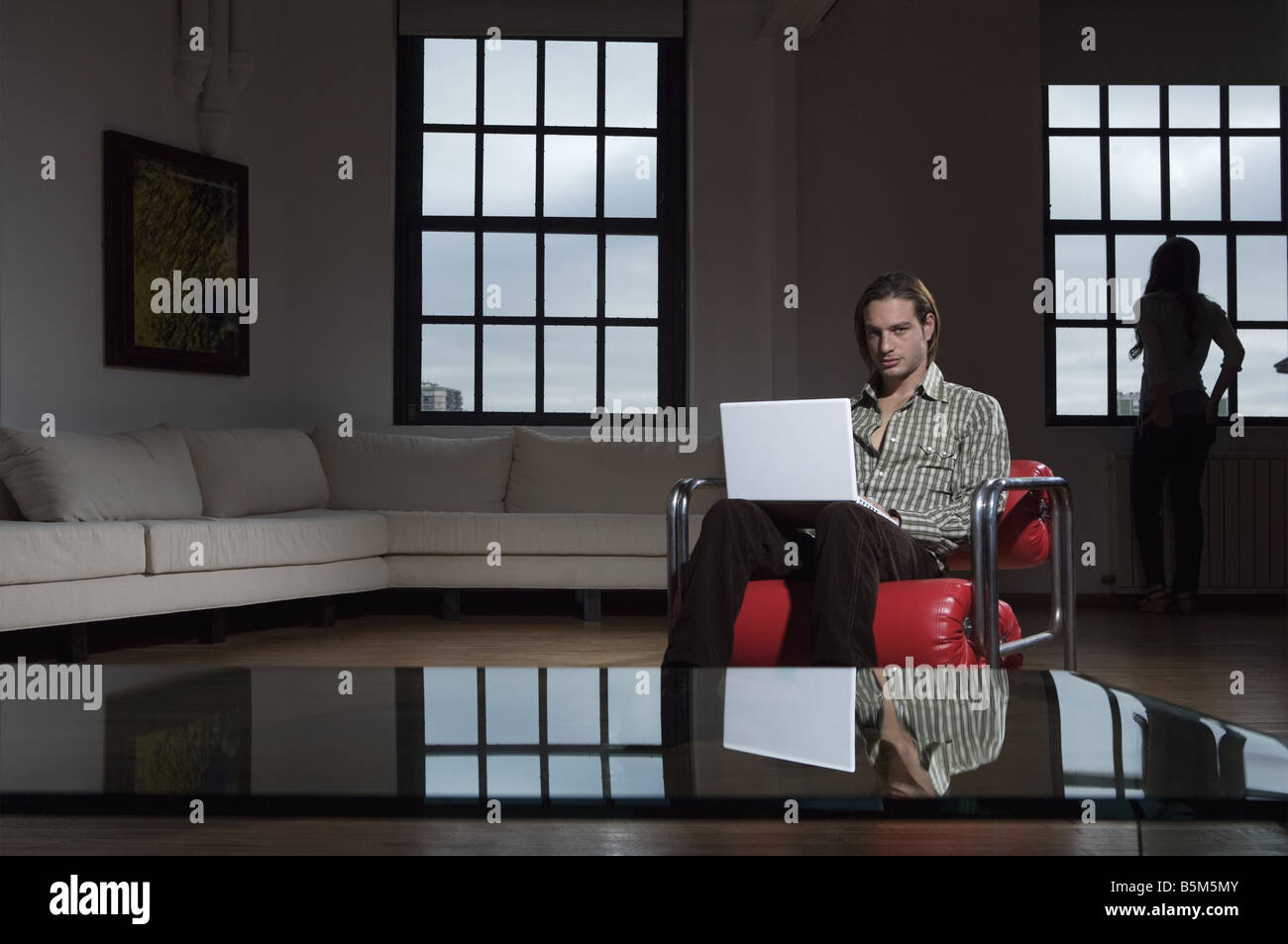 Young man and woman with computer in a living room Stock Photo - Alamy