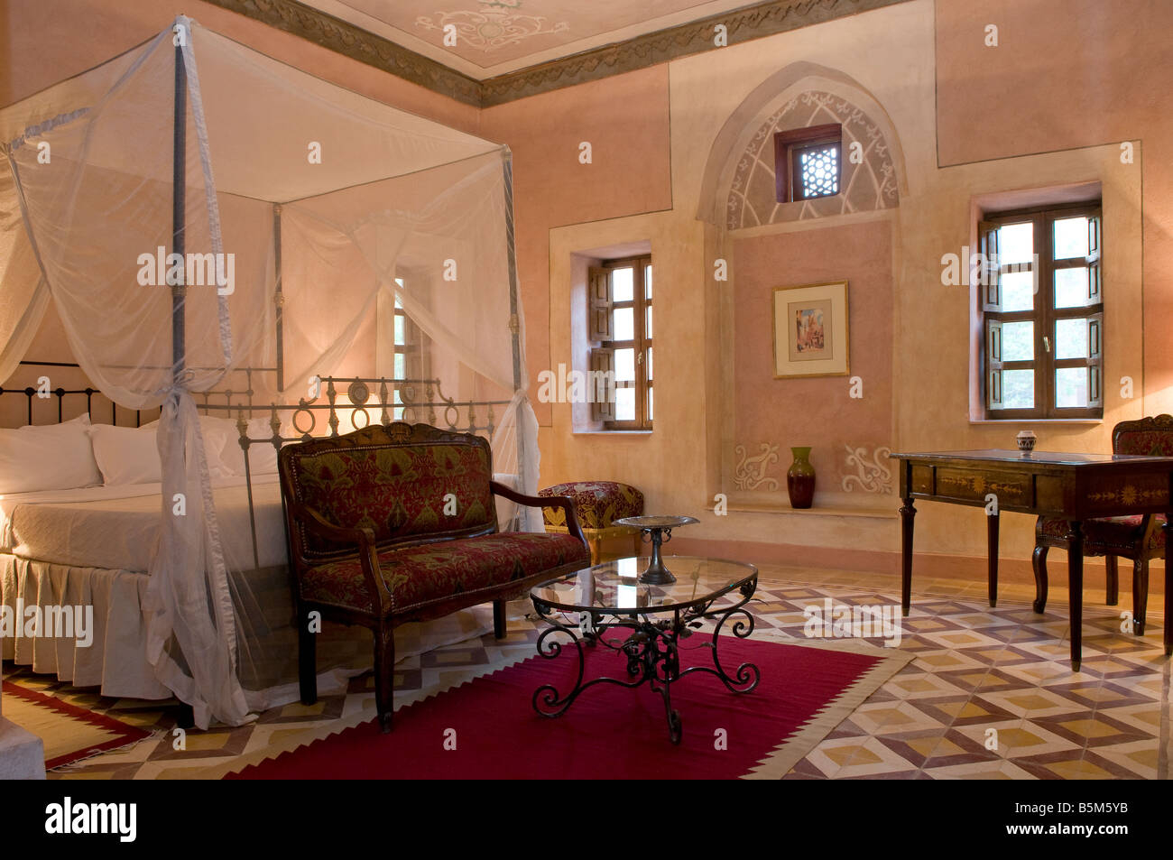 A bedroom with a draped mosquito net in Al Moudira boutique hotel ...