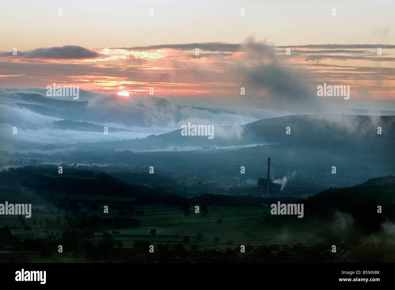 dawn over castleton valley from mam tor with the cement works low mist ...