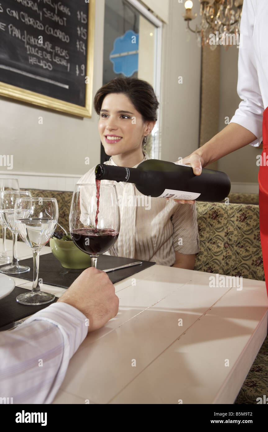 Waitress pouring a glass of wine Stock Photo - Alamy