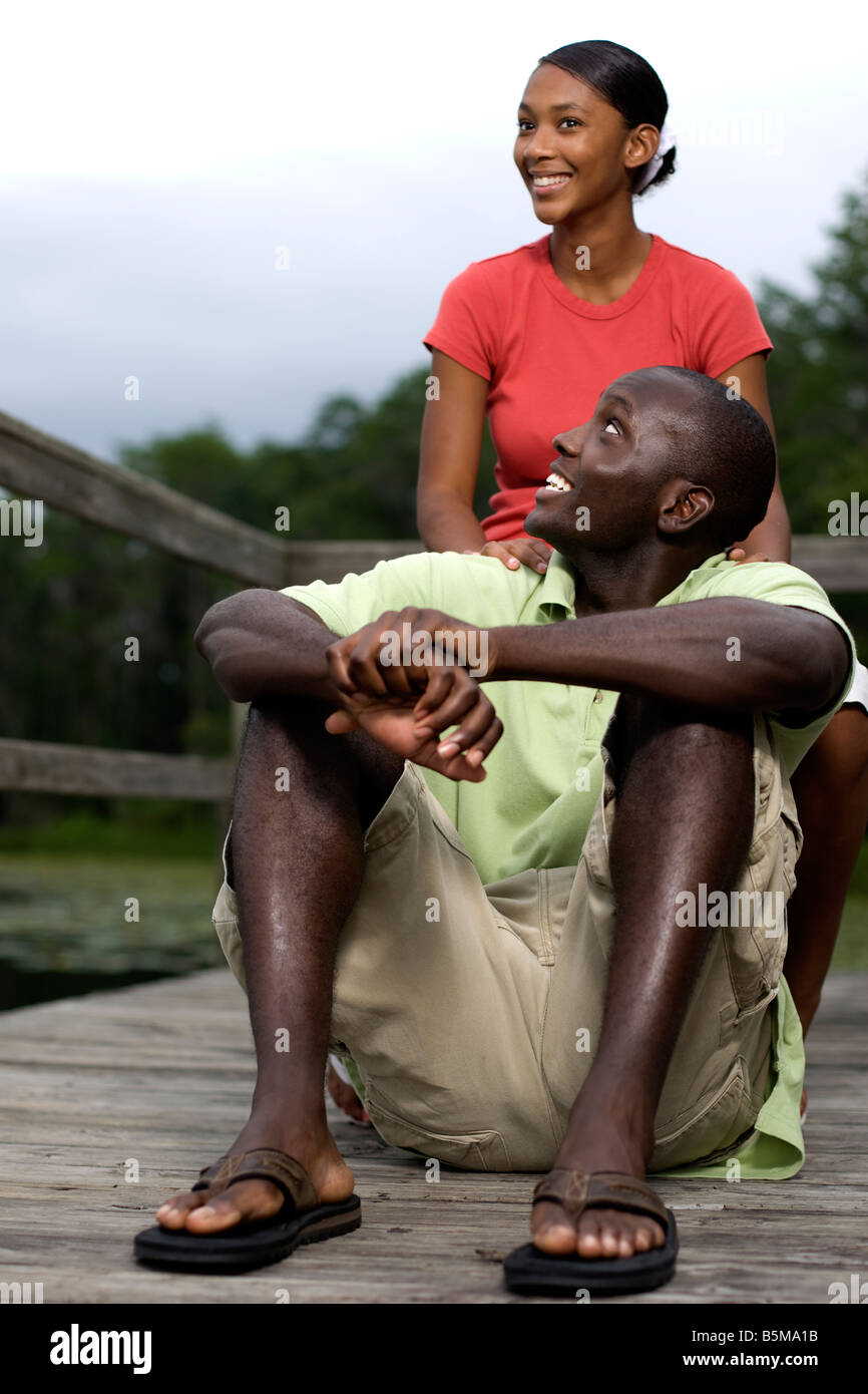 Two young people, a man and a woman, hang out on a dock in Orlando ...